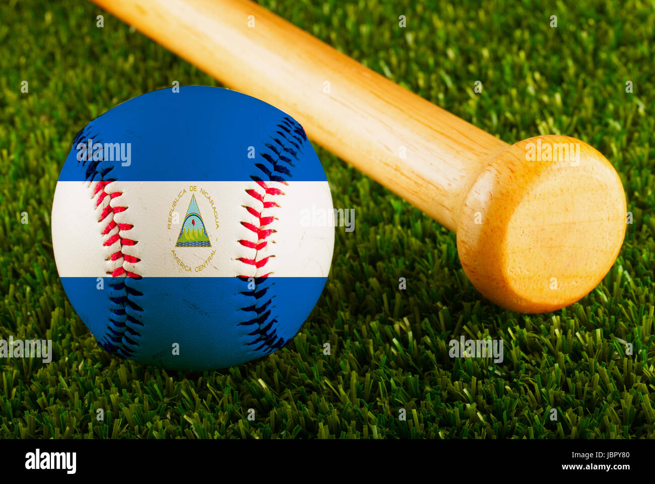 Baseball with Nicaragua flag and bat over a background of green grass ...
