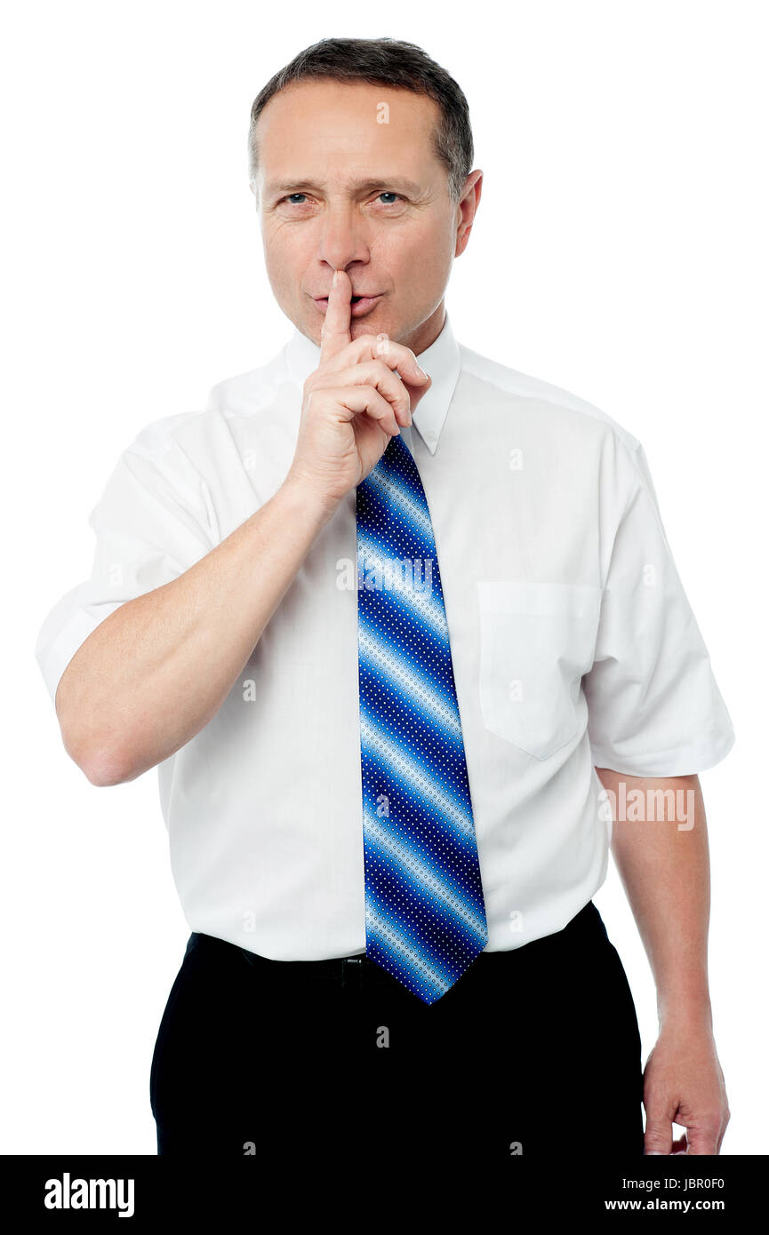 Modern businessman showing shh gesture Stock Photo - Alamy