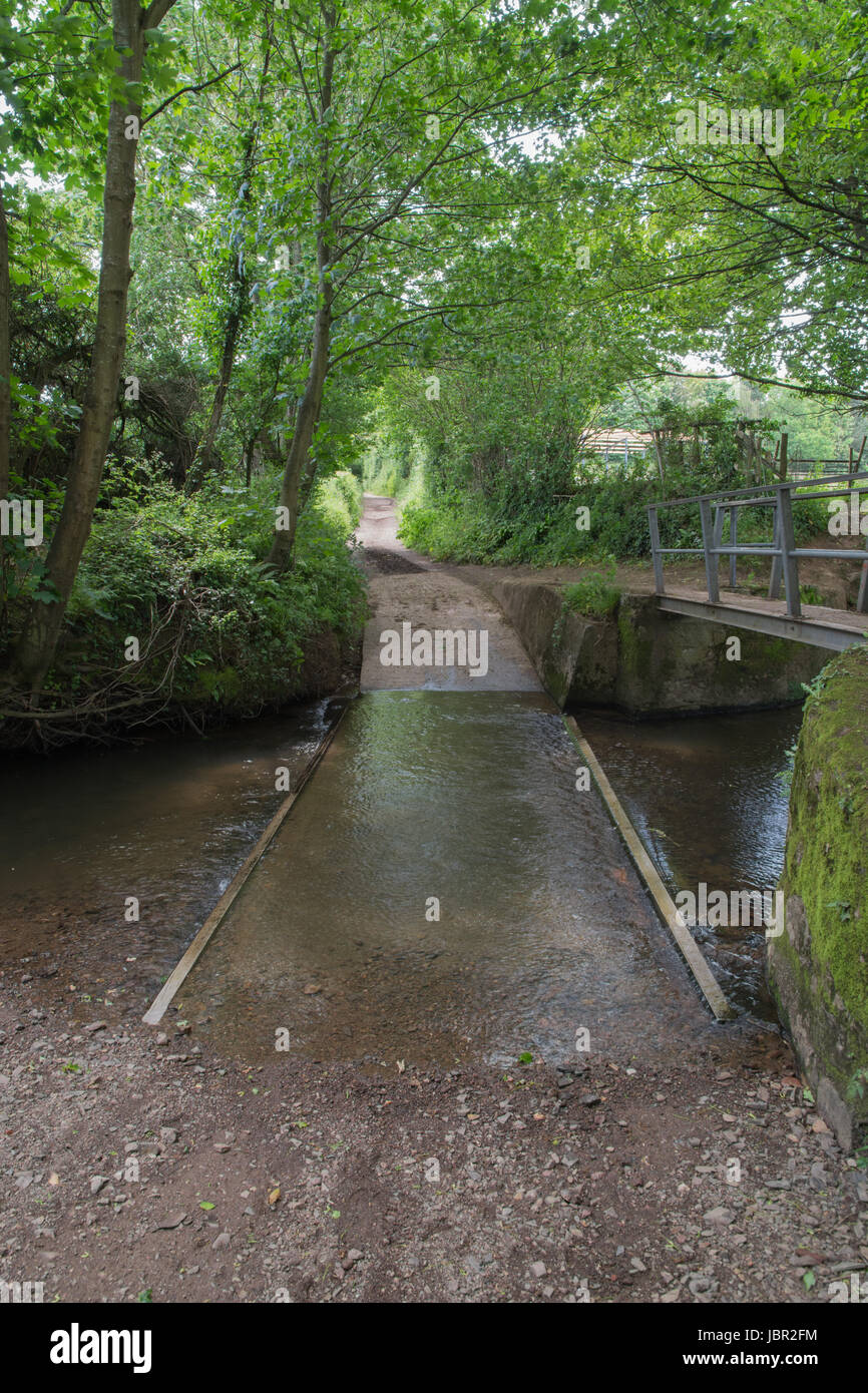 A ford and footbridge provide a crossing for a secluded track Stock ...