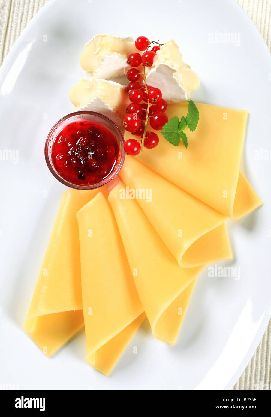 Two kinds of cheese and red currant sauce Stock Photo - Alamy