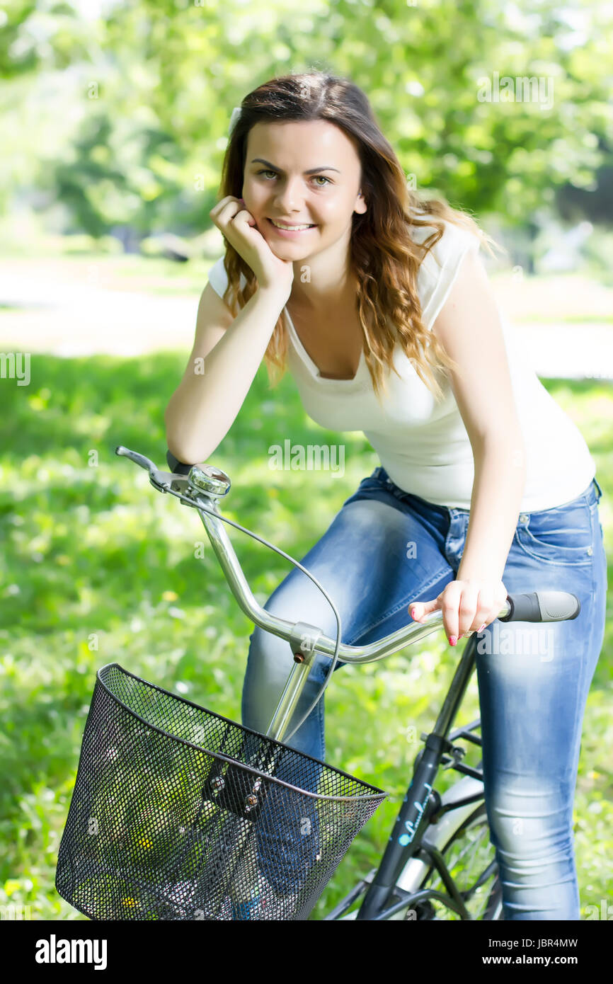 Beautiful young woman enjoying nature riding a bike Stock Photo - Alamy