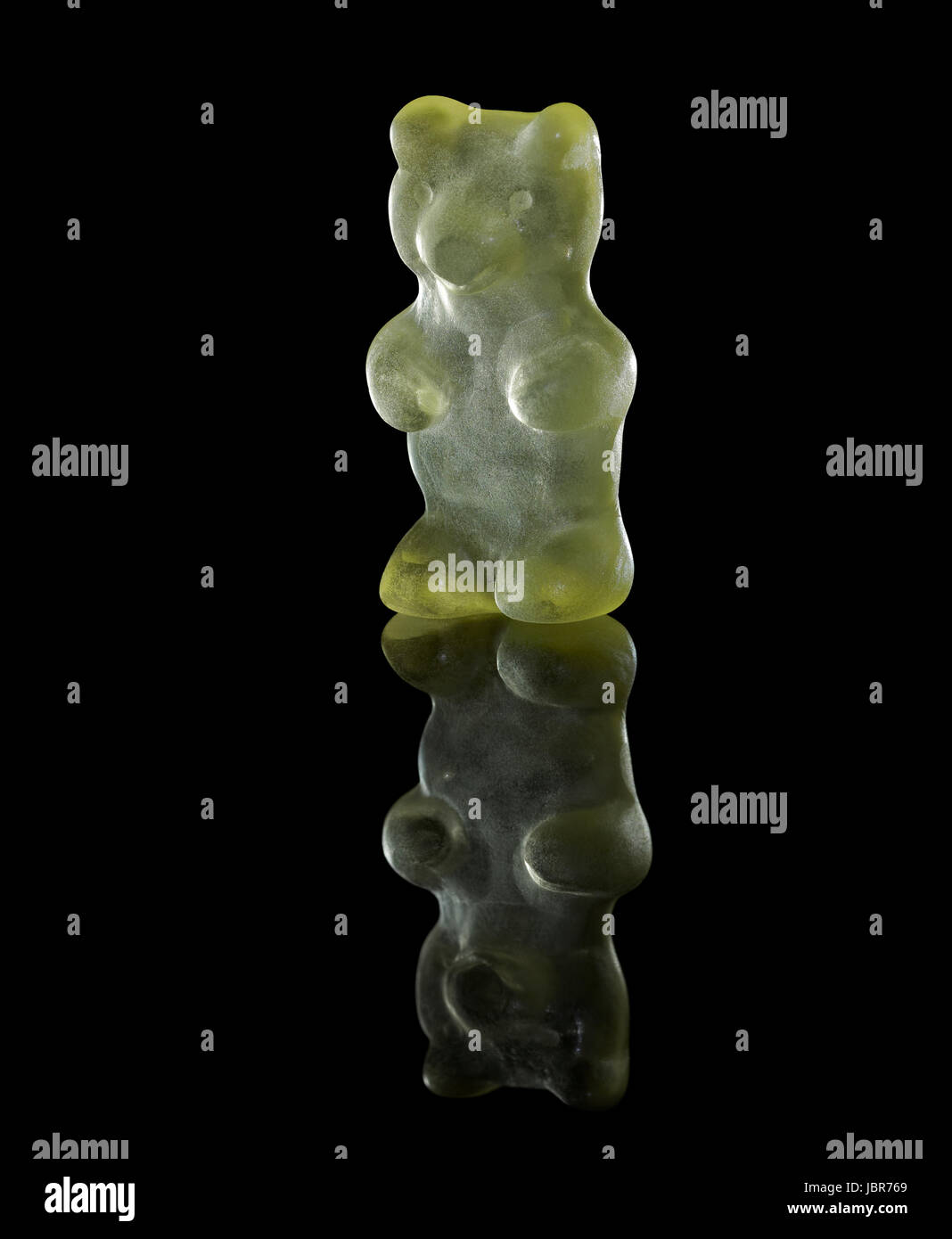 green translucent gummy bear in black reflective back Stock Photo - Alamy