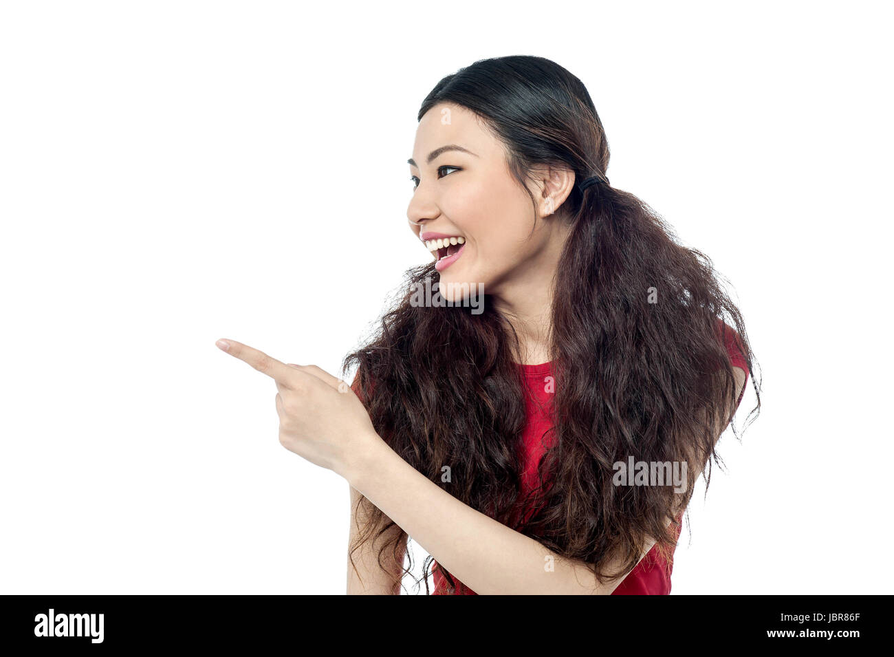 Smiling pretty girl pointing at something Stock Photo - Alamy