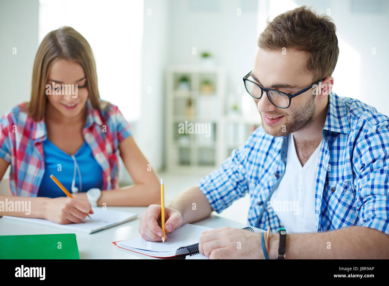 Successful student and his groupmate on background carrying out test at ...
