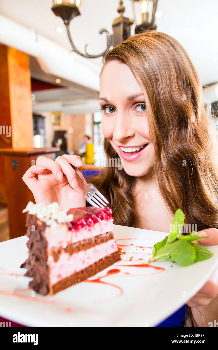 Young woman eating fruit cake at cafe or bakery Stock Photo - Alamy