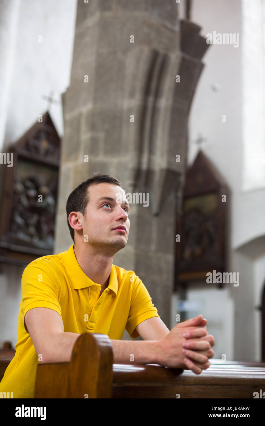 Handsome young man praying in a church Stock Photo - Alamy
