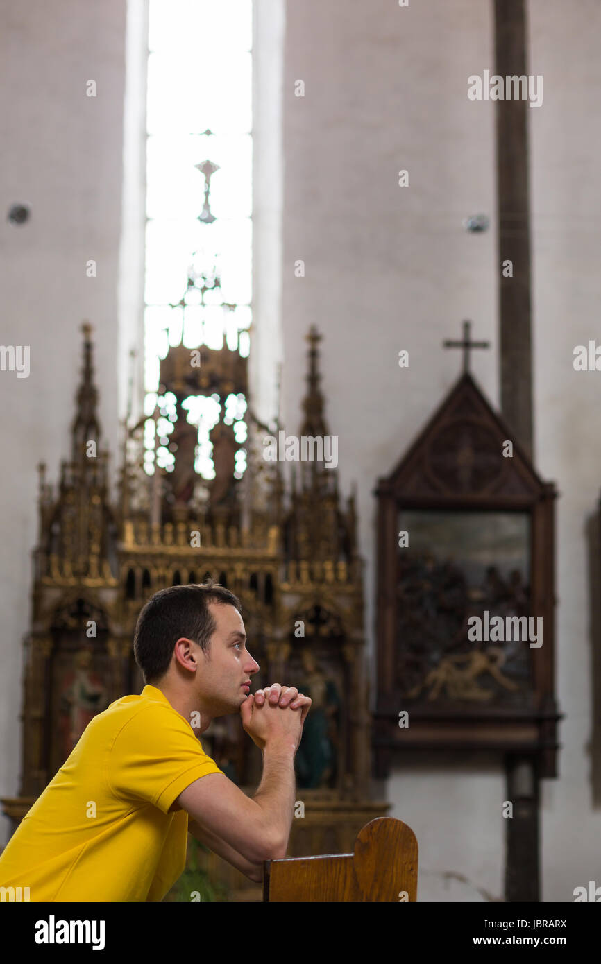 Handsome young man praying in a church Stock Photo - Alamy