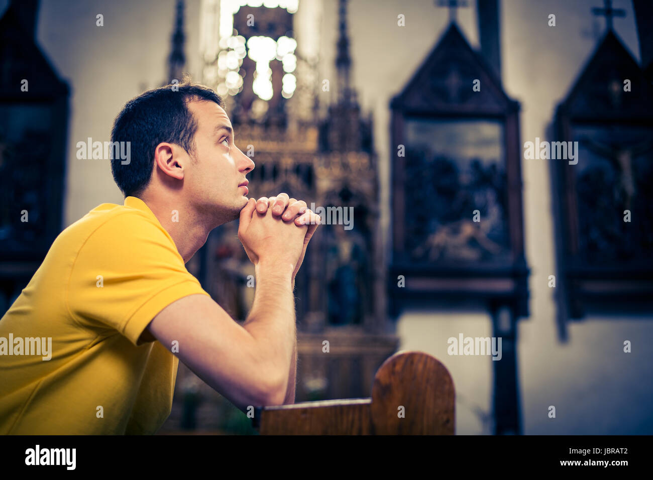 Handsome young man praying in a church Stock Photo - Alamy