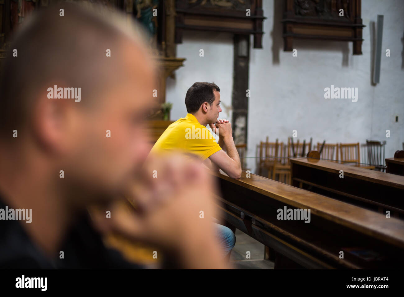 Handsome young man praying in a church Stock Photo - Alamy