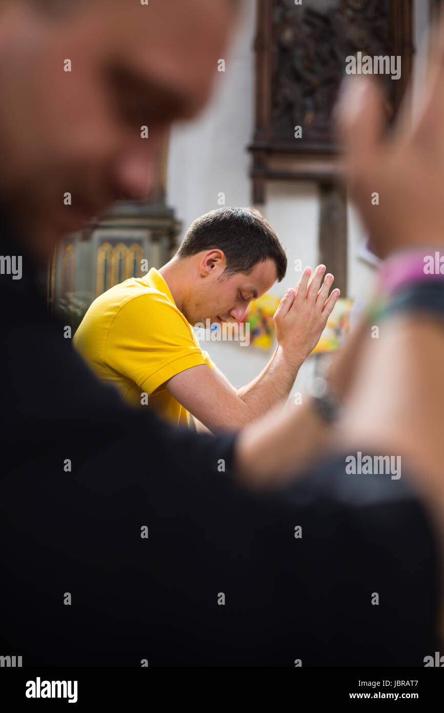 Handsome young man praying in a church Stock Photo - Alamy