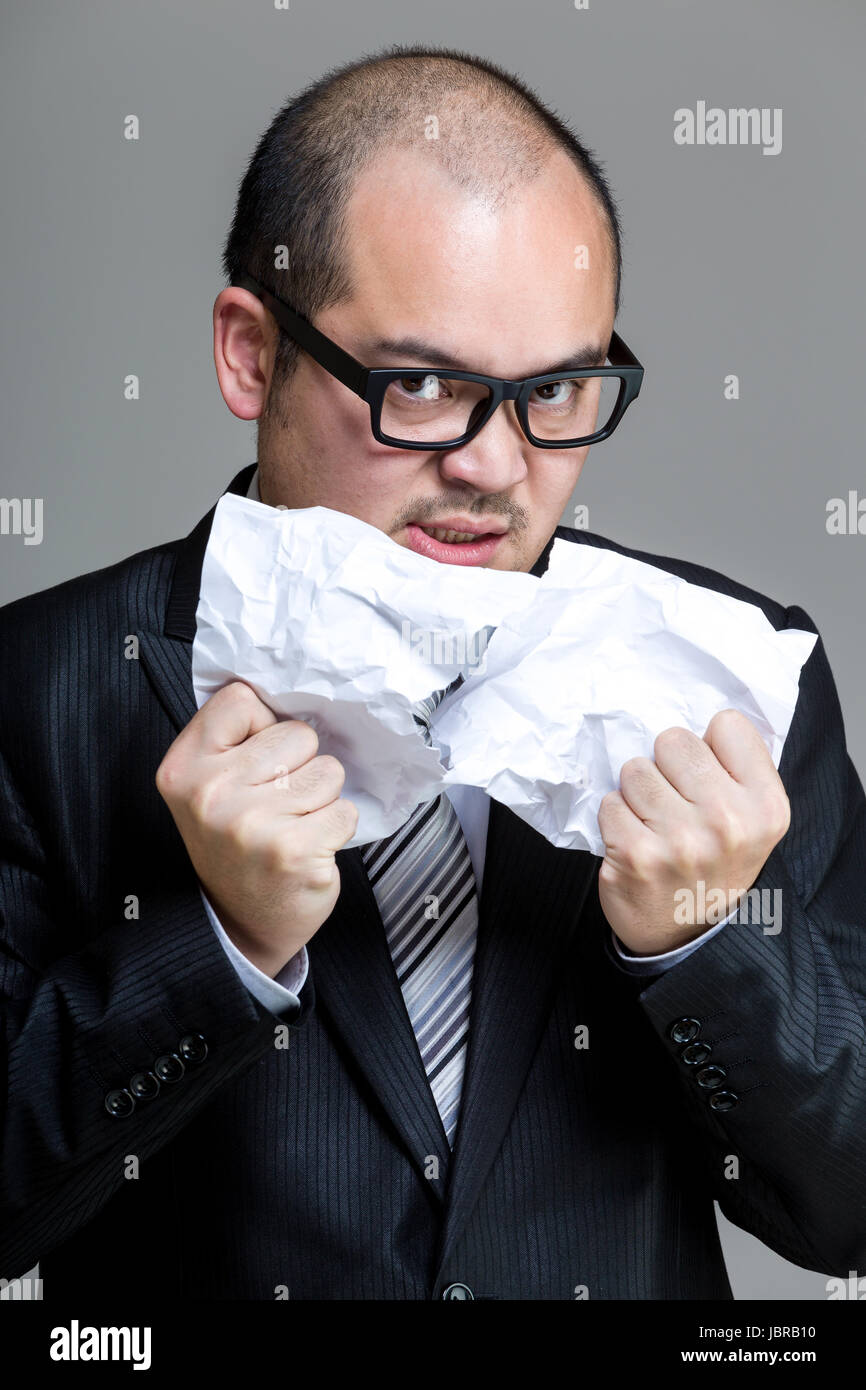 Angry business man tear paper off Stock Photo - Alamy