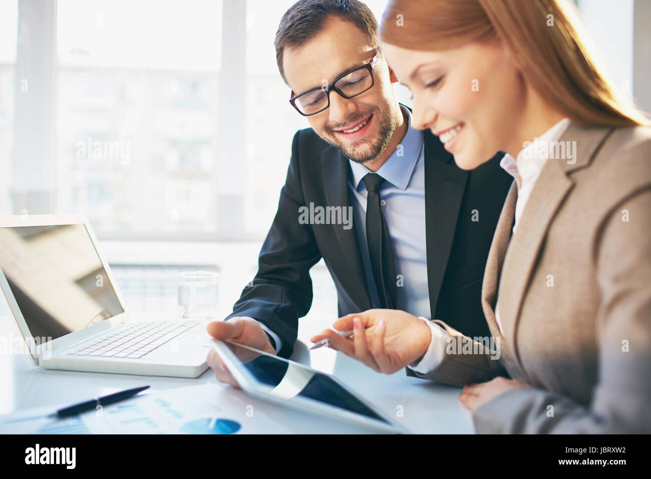 Young businesswoman explaining report to her colleague at meeting Stock ...
