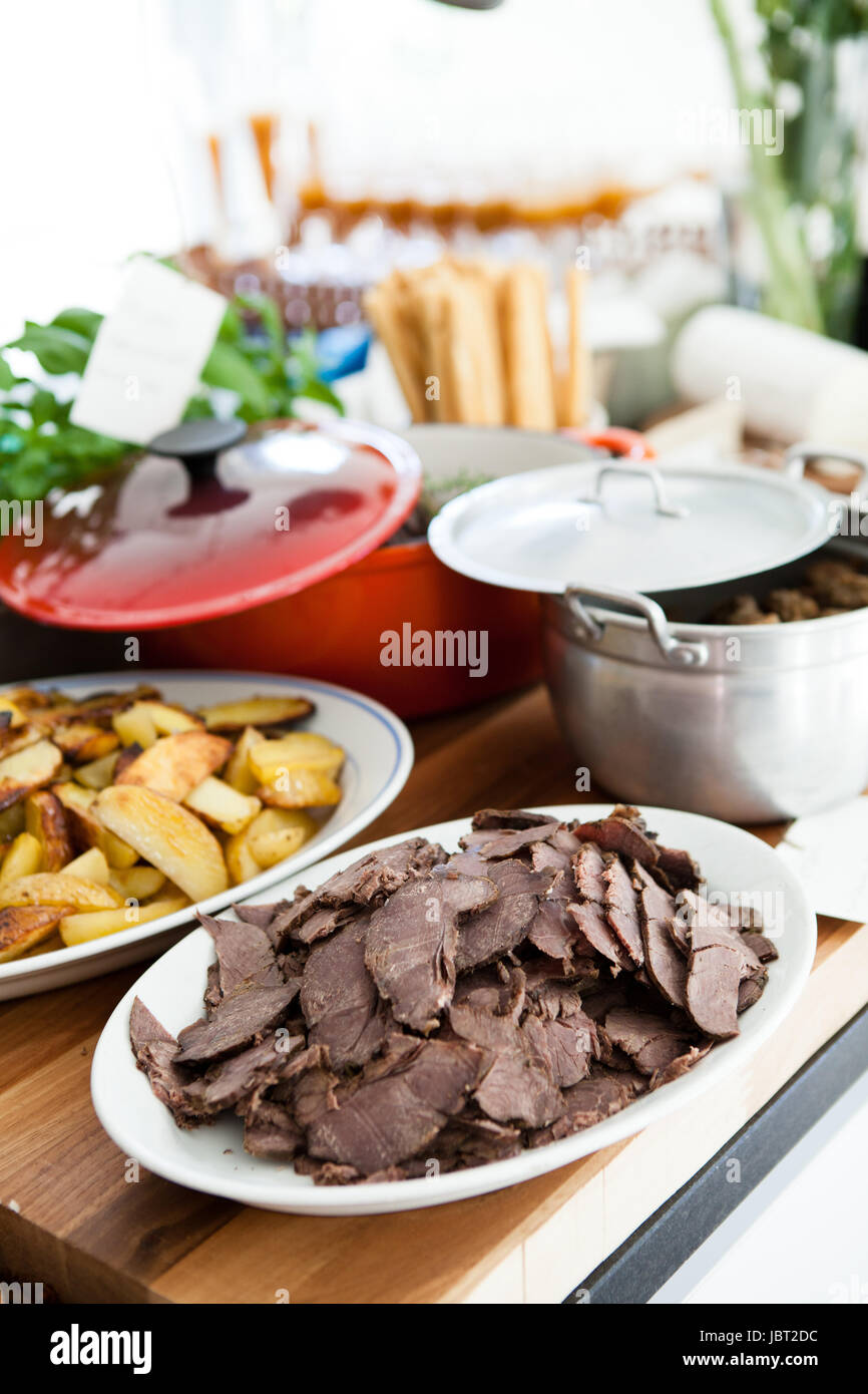 Closeup of plates of cooked meat and thick style french fries and ...