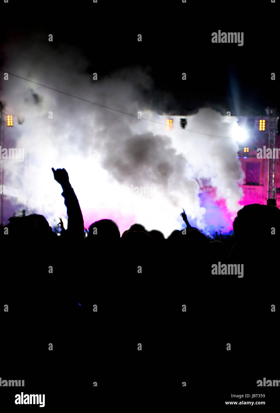 Cheering crowd in front of bright colorful stage lights Stock Photo - Alamy