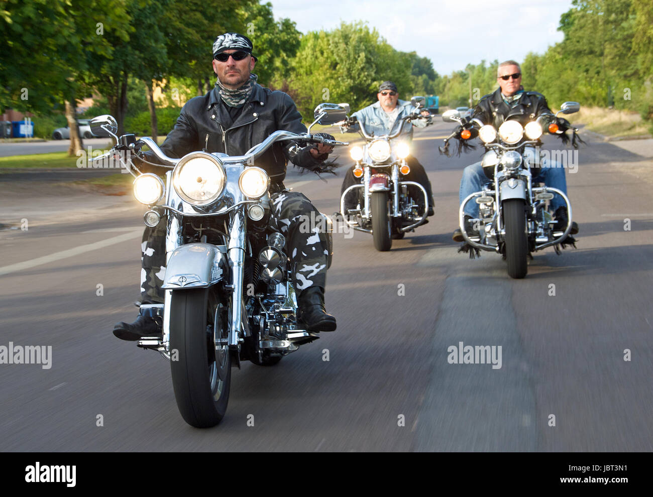 A group of Harley Davidson motorcycles and riders on the road with ...