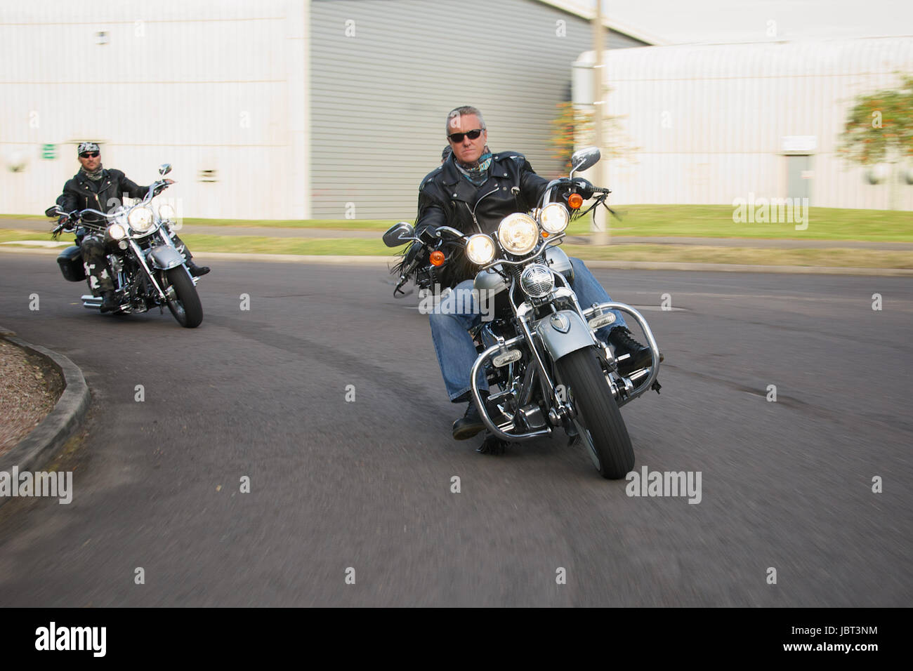 A group of Harley Davidson motorcycles and riders on the road with ...