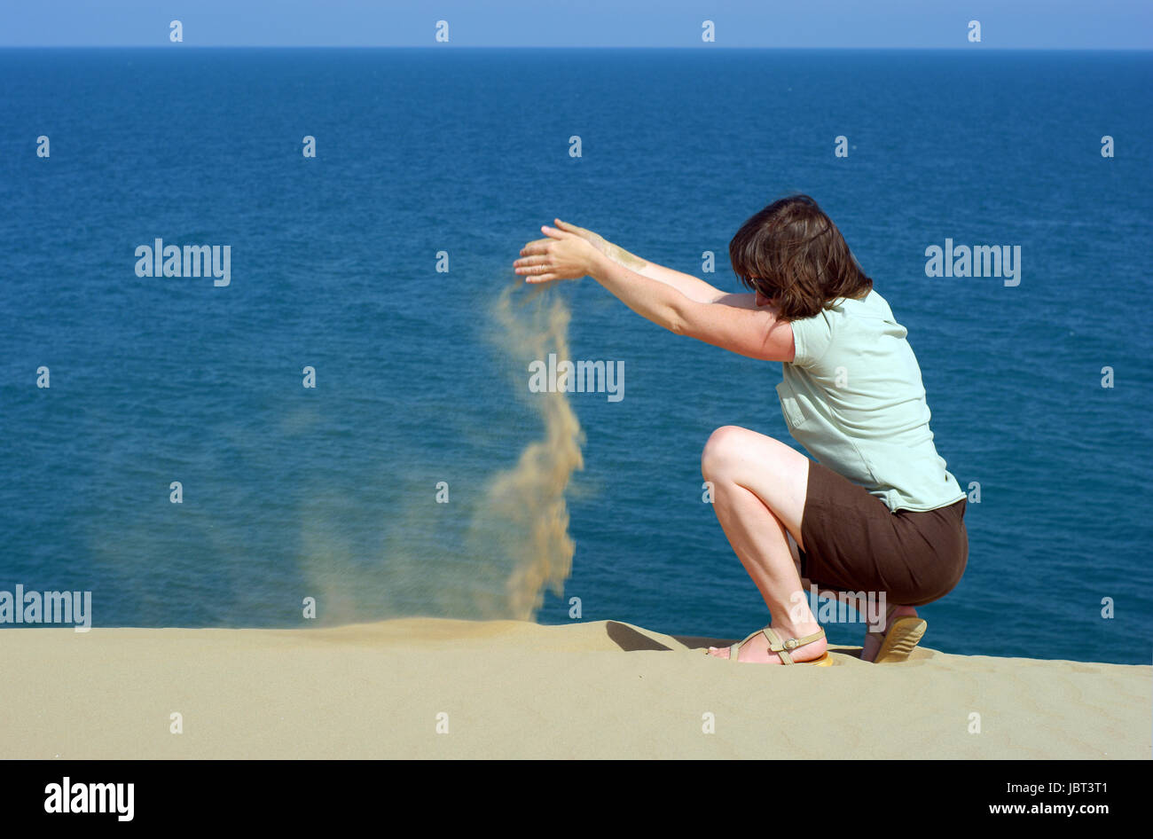 Women and sand on a beach. Sand in female hand Stock Photo - Alamy