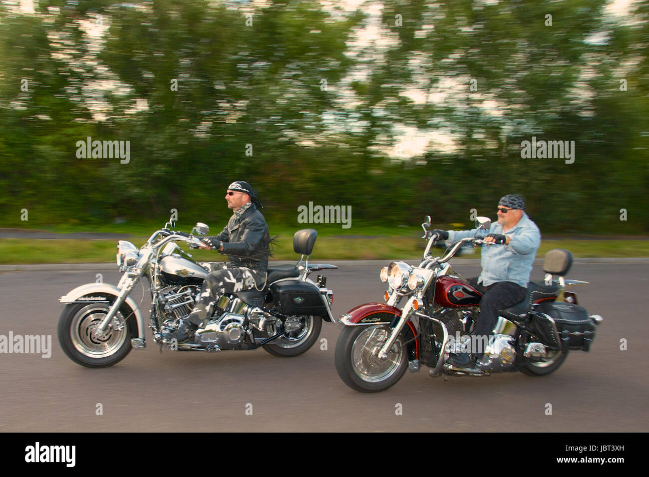 A group of Harley Davidson motorcycles and riders on the road with ...