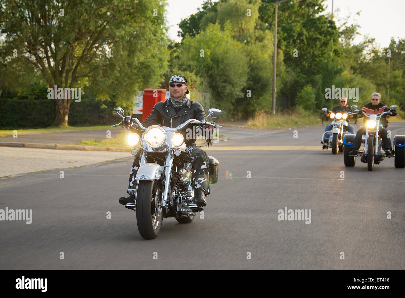 A group of Harley Davidson motorcycles and riders on the road with ...