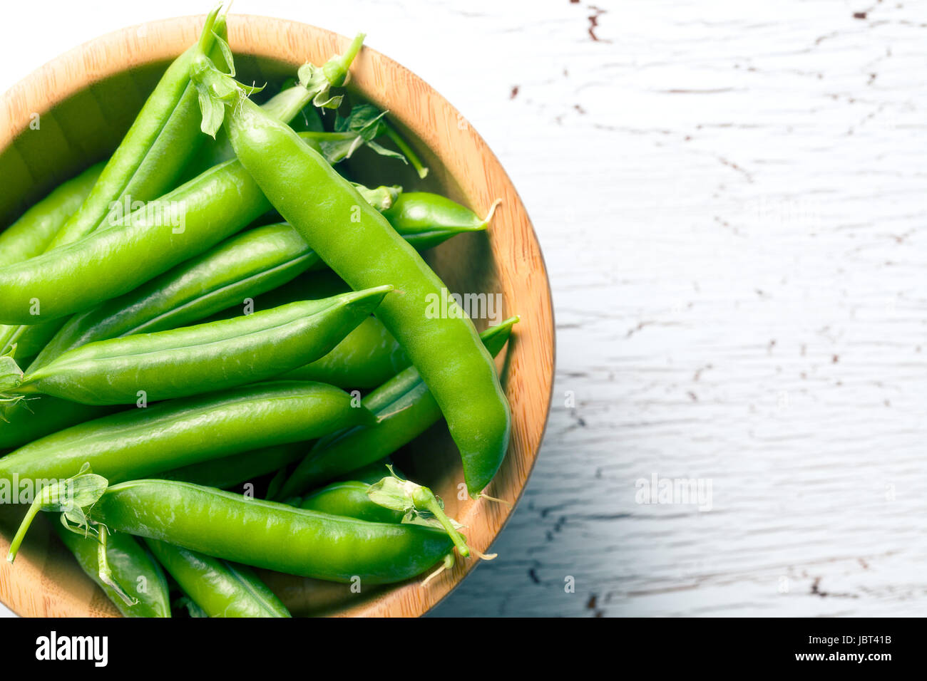green pea pods in wooden bowl on cracked background Stock Photo - Alamy