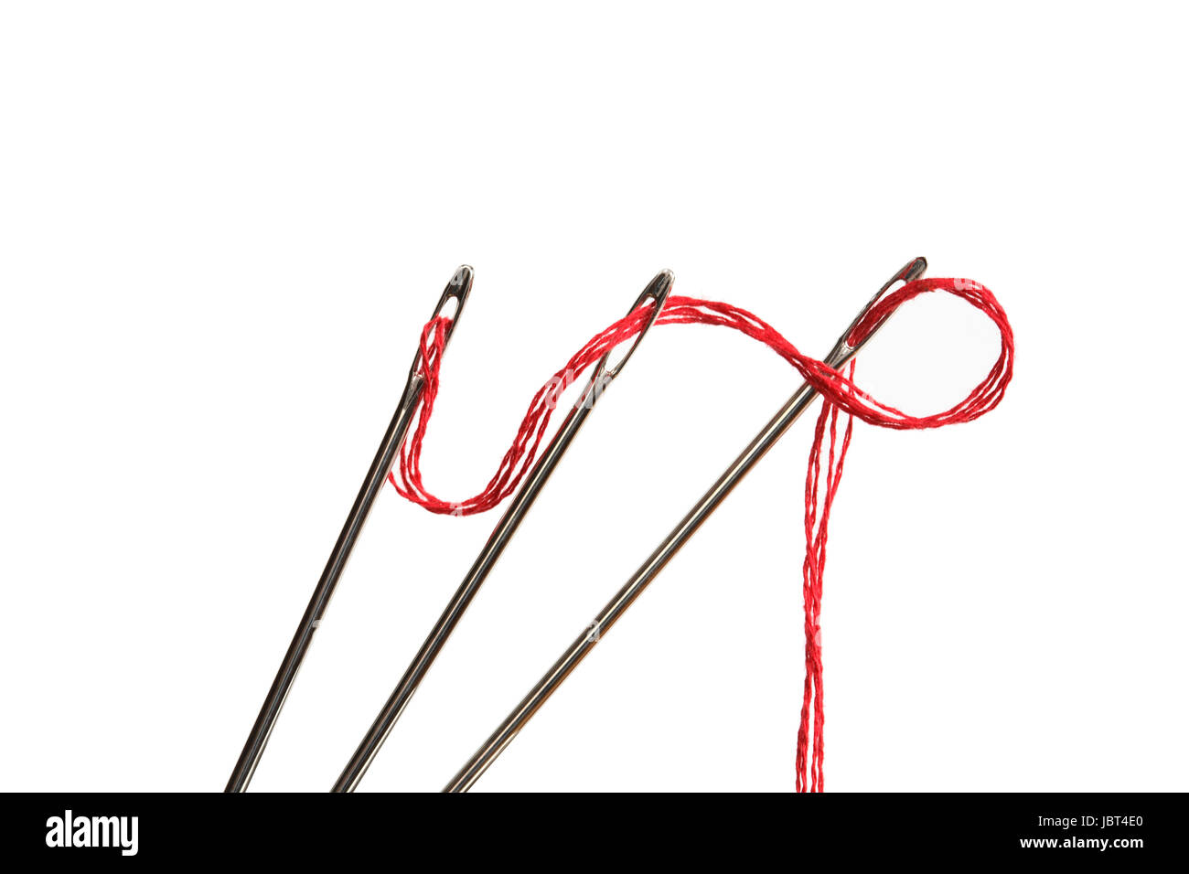 Sewing concept. Closeup of three needles with red thread on white ...