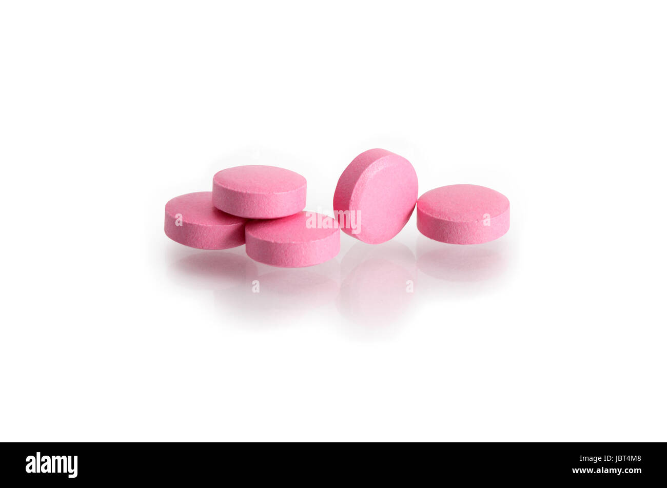 Closeup of few colored pills on white background with reflection ...