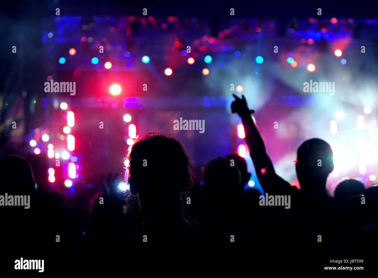 Cheering crowd in front of bright colorful stage lights Stock Photo - Alamy