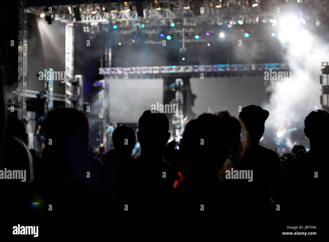 Cheering crowd in front of bright colorful stage lights Stock Photo - Alamy
