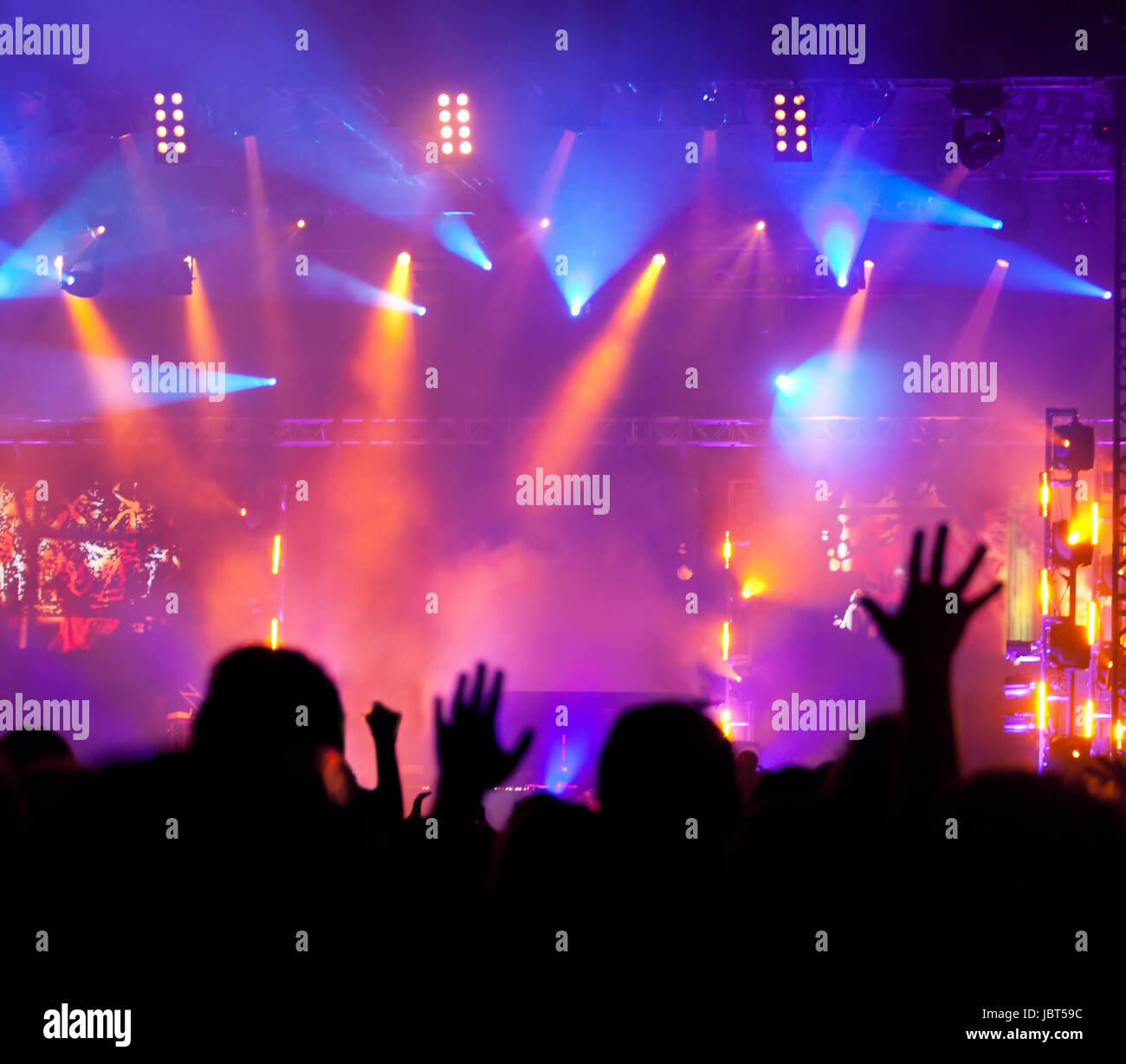 Cheering crowd in front of bright colorful stage lights Stock Photo - Alamy
