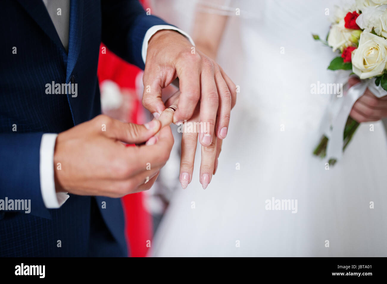 Amazing couple putting wedding rings on fingers of each other. Close up ...