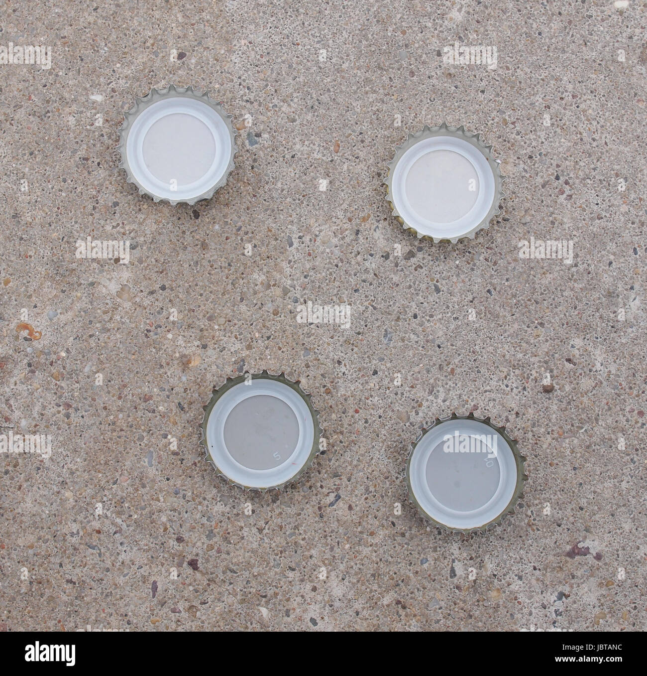 Beer bottle caps over concrete floor Stock Photo - Alamy
