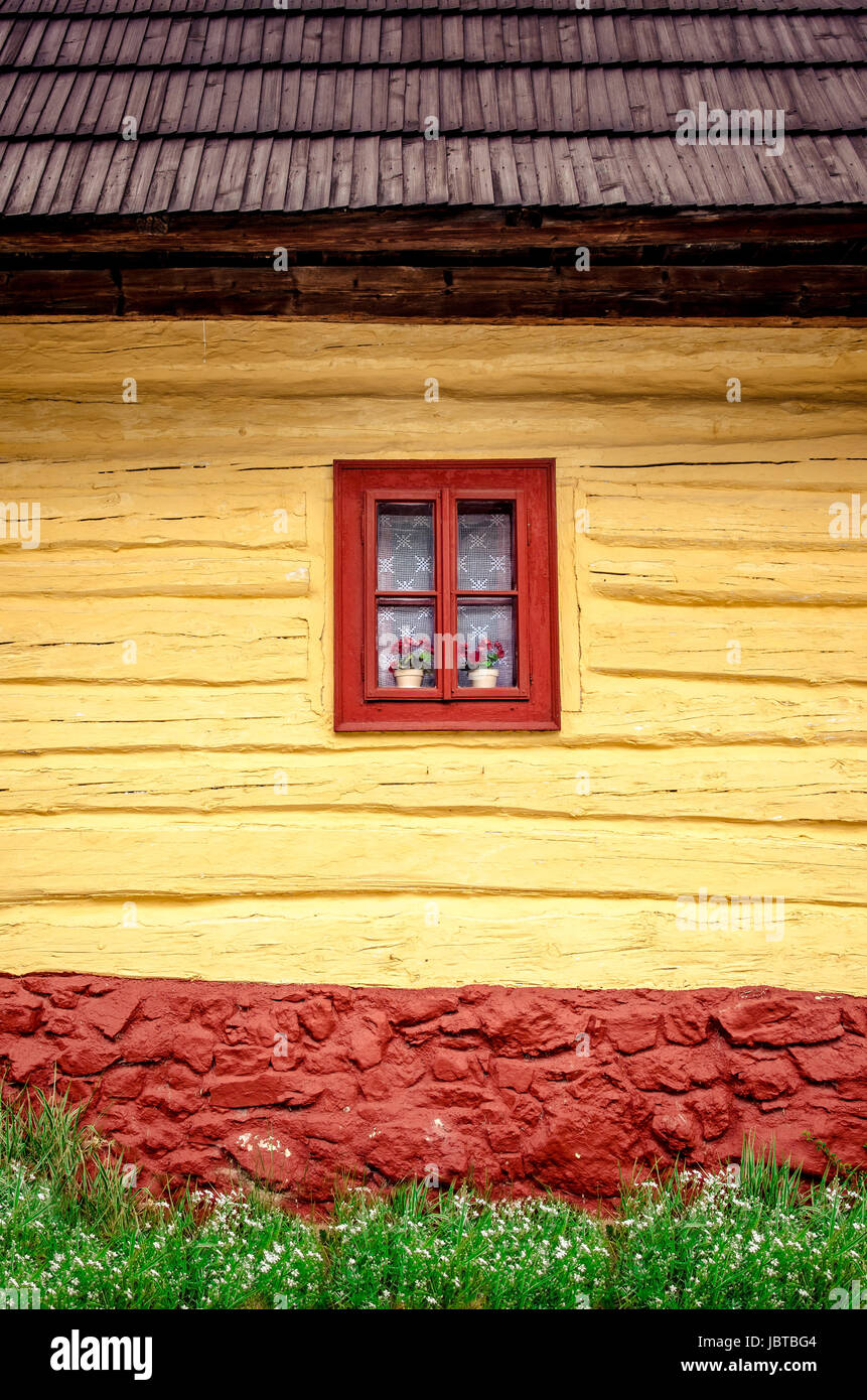 Detail of colorful window with flowers on old traditional wooden house ...