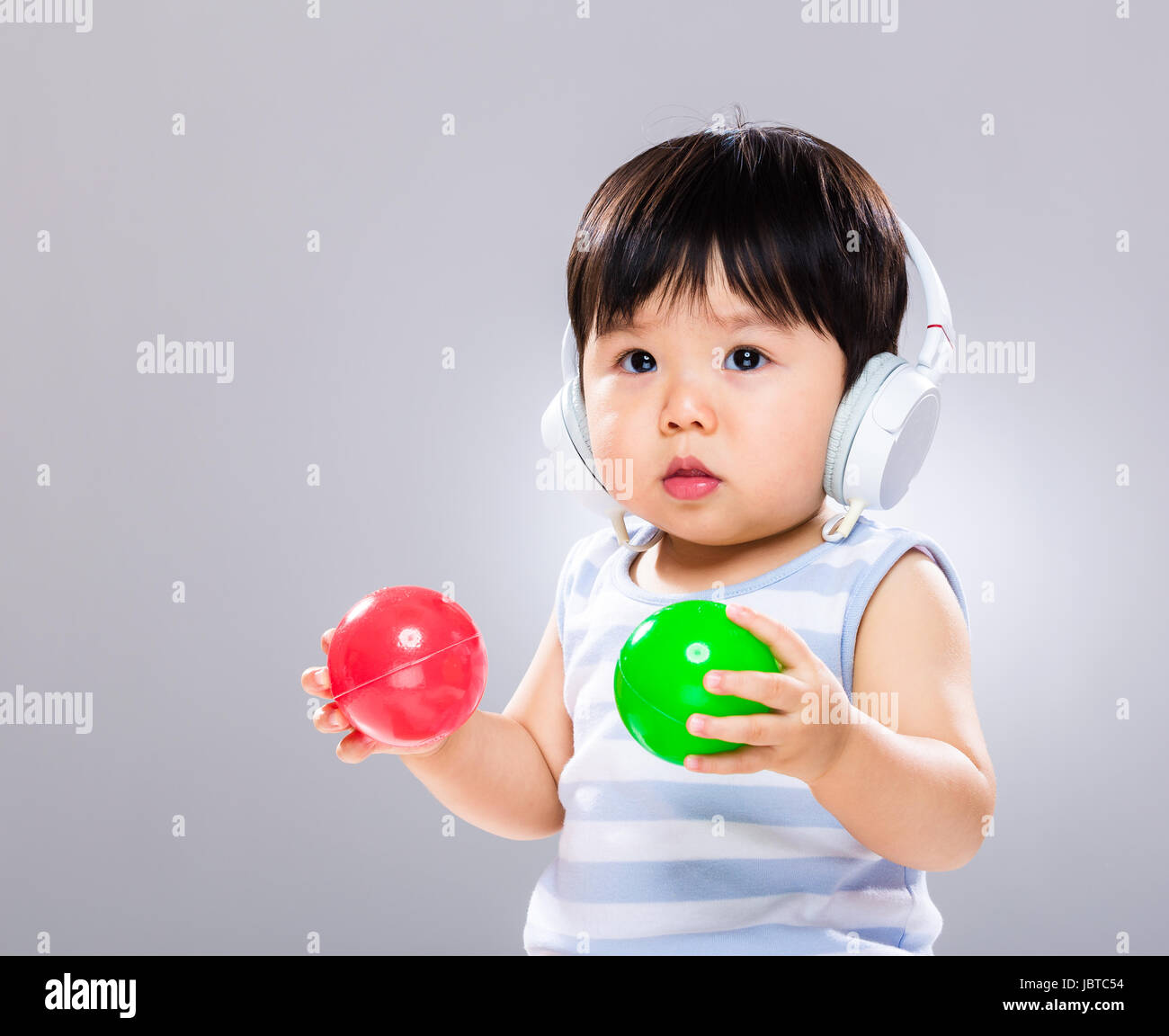 Baby listen to music and play ball Stock Photo - Alamy