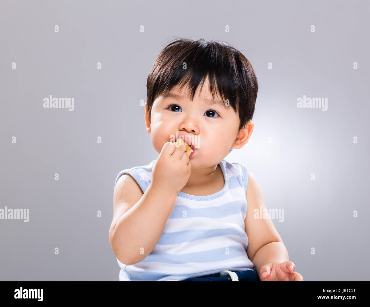 Baby boy eating biscuit Stock Photo - Alamy
