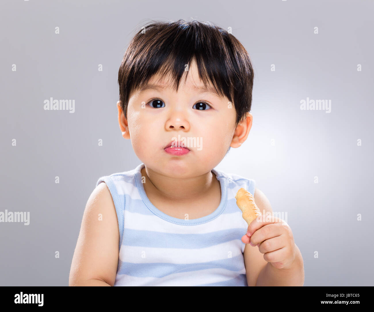 Little boy eating biscuit Stock Photo - Alamy