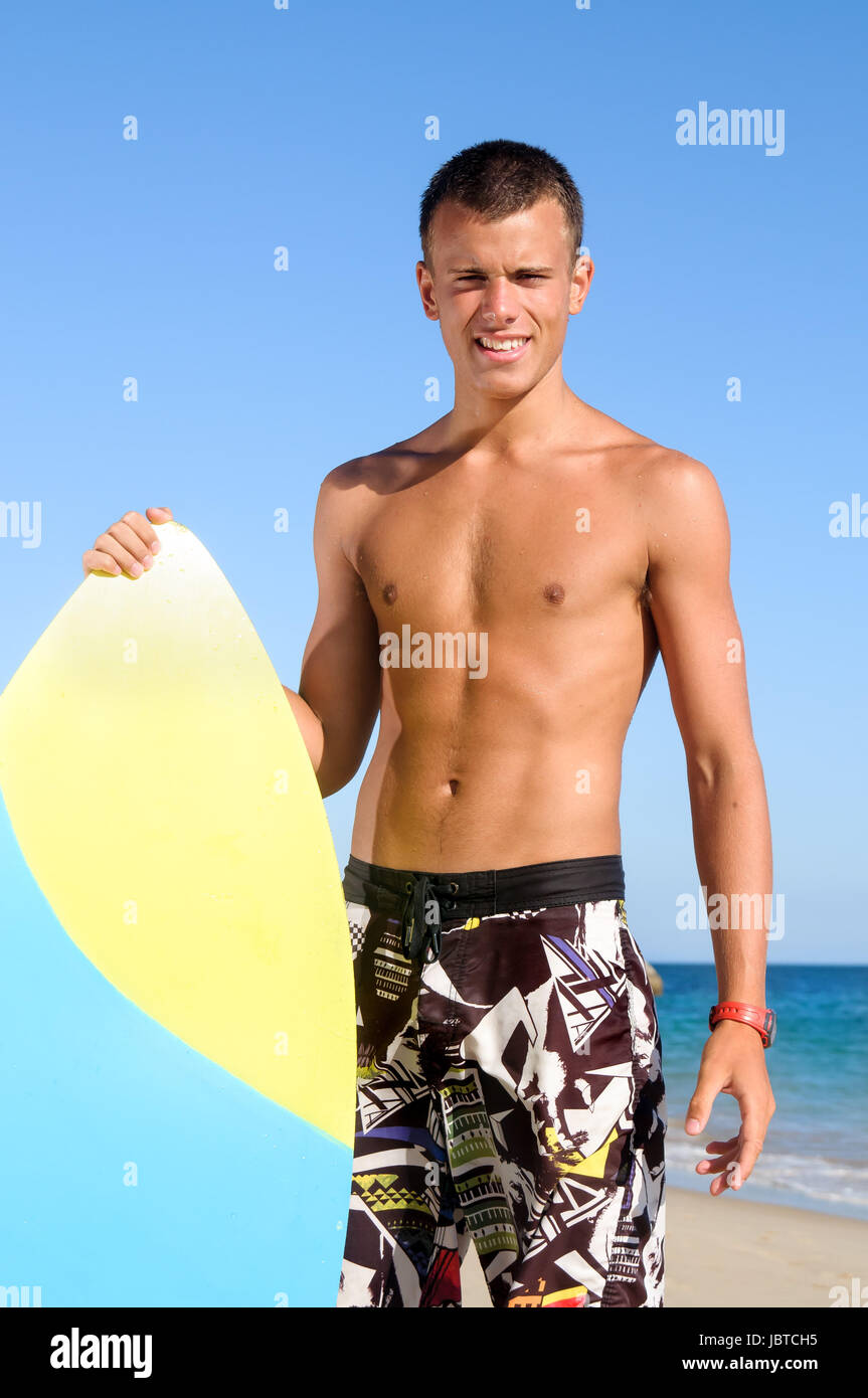 Handsome surfer posing in the beach Stock Photo - Alamy
