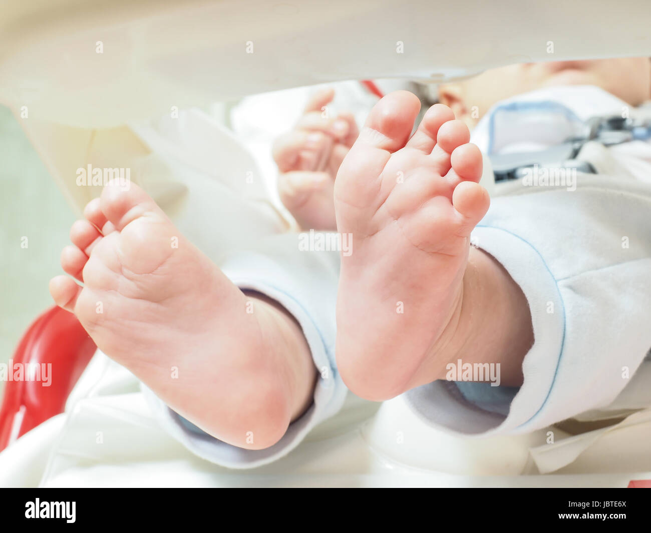 Baby feet stretching at feeding table with blue clothes Stock Photo - Alamy