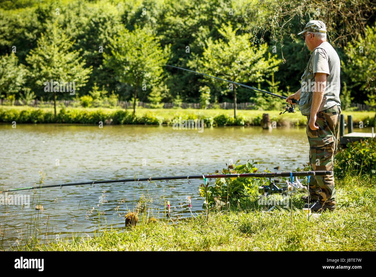 Man fishing on a lake Stock Photo - Alamy