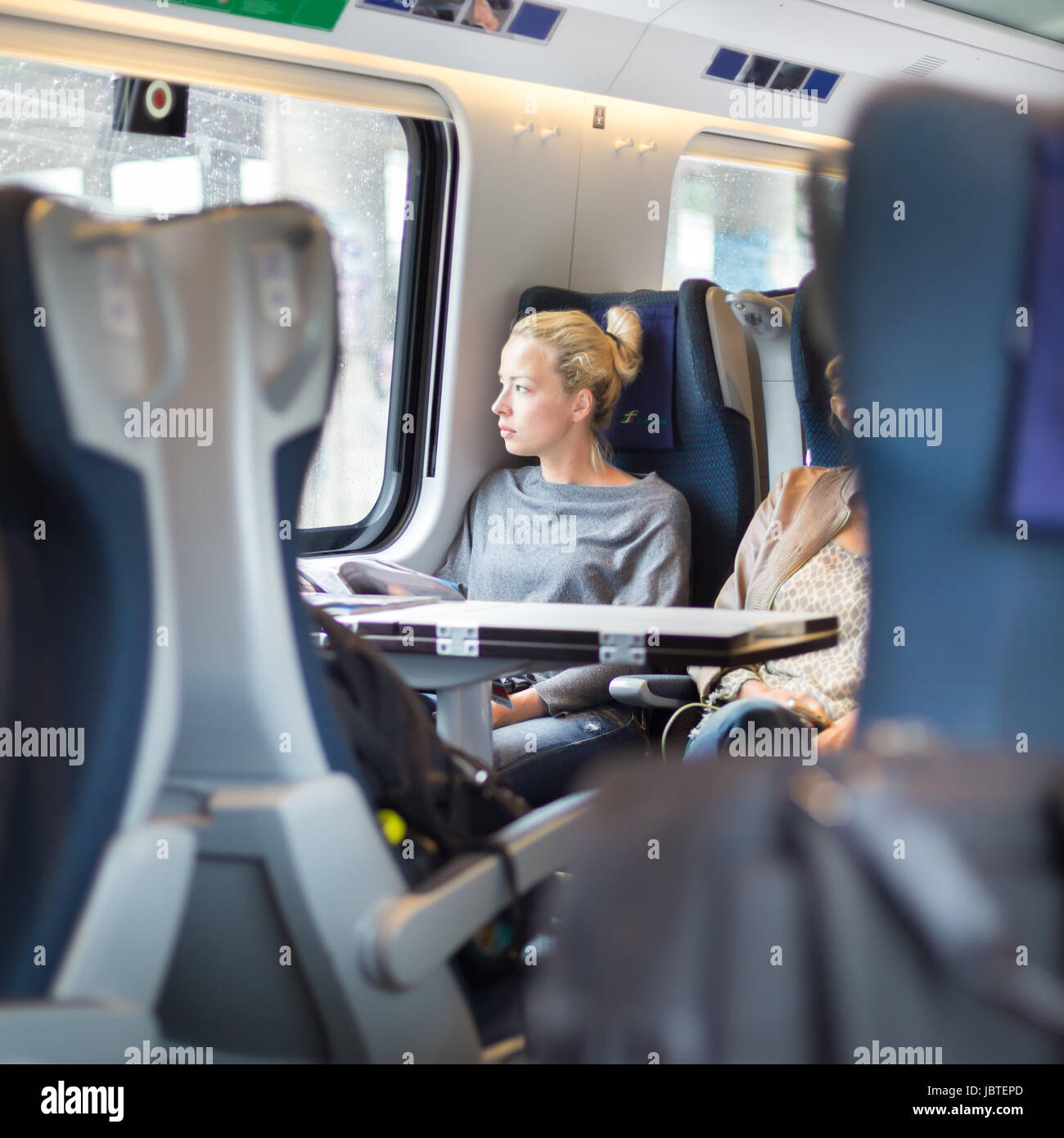 Blonde casual caucasian lady traveling by train Stock Photo - Alamy