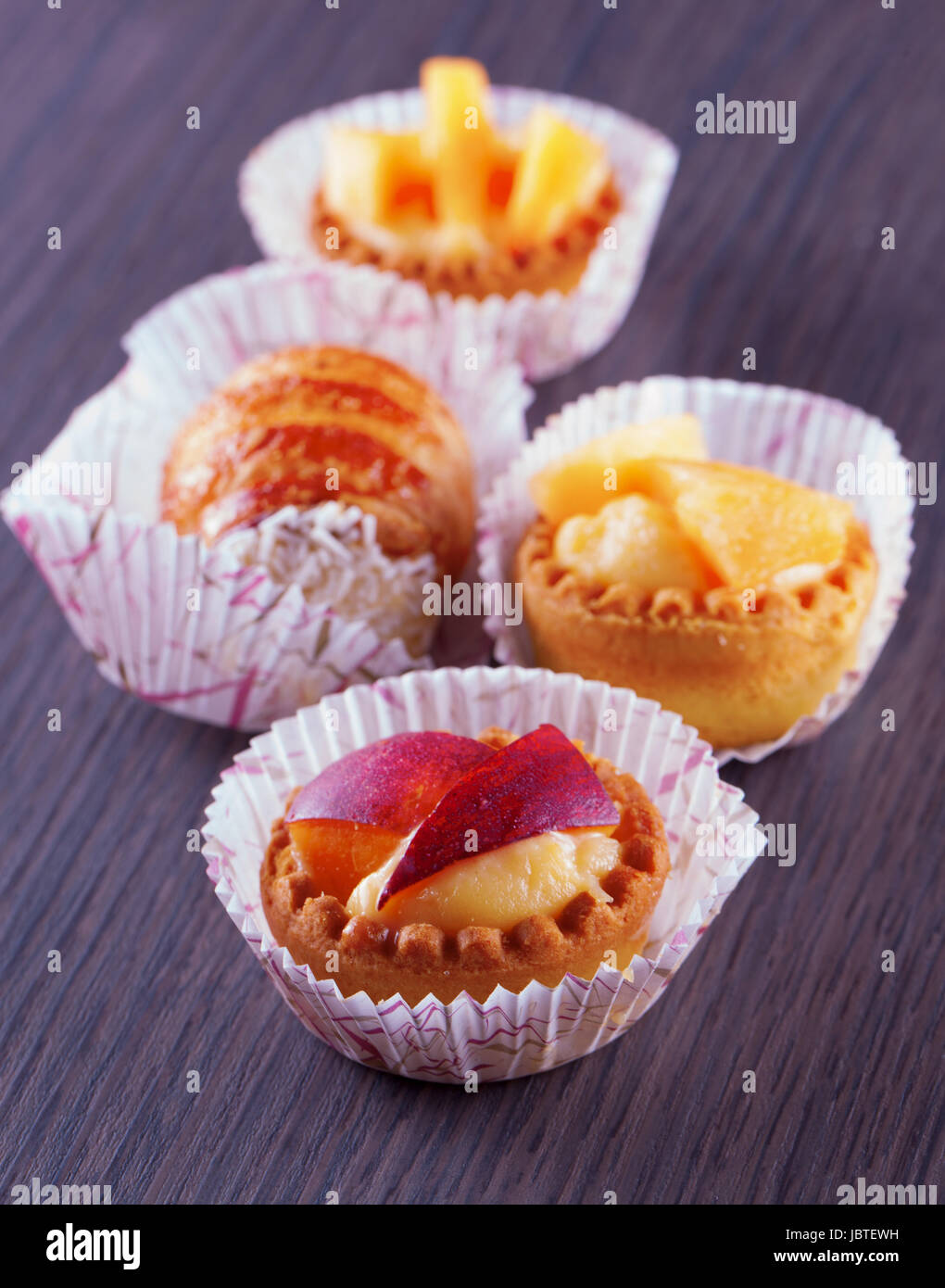 Different pastries over a dark wooden table Stock Photo - Alamy