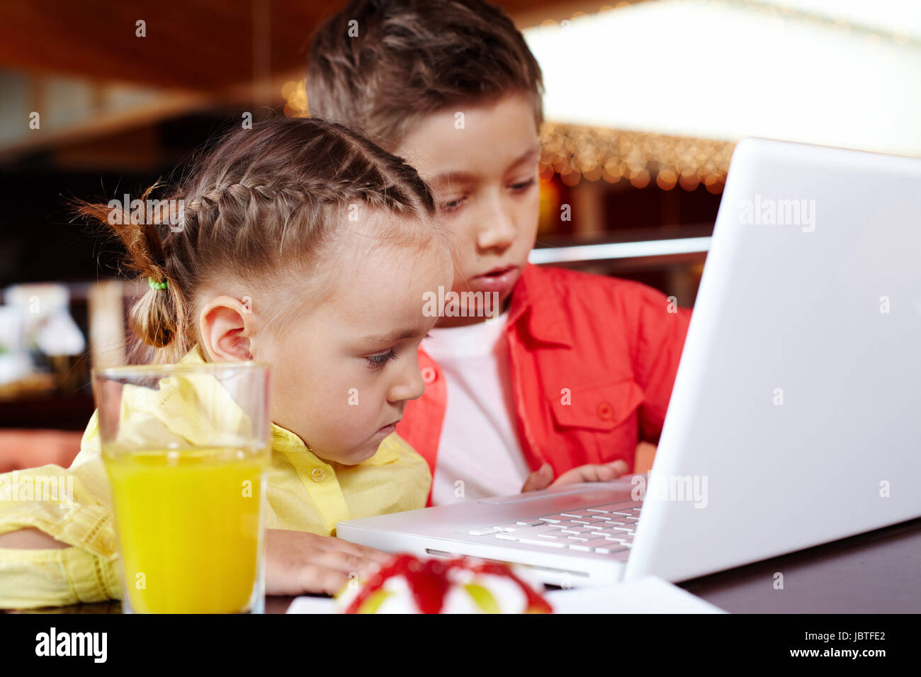 Portrait of cute children typing on laptop Stock Photo - Alamy