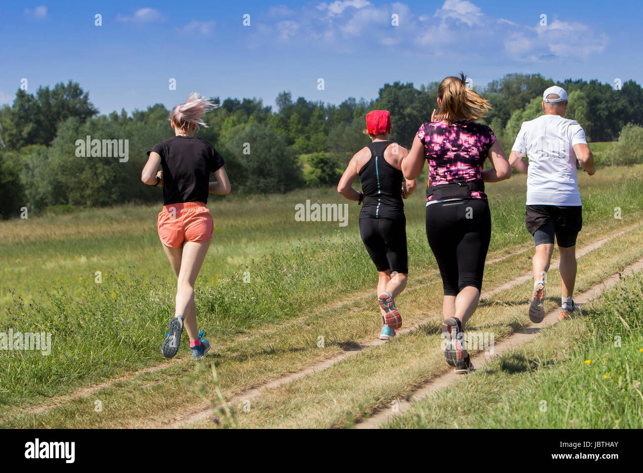 Outdoor cross-country running, Group of active people running in nature ...