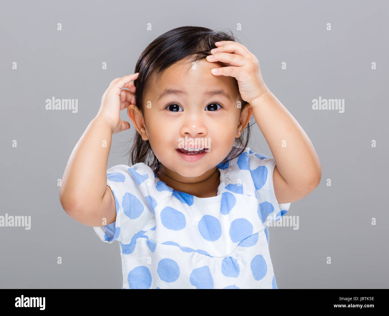 Baby girl hand touch head Stock Photo - Alamy