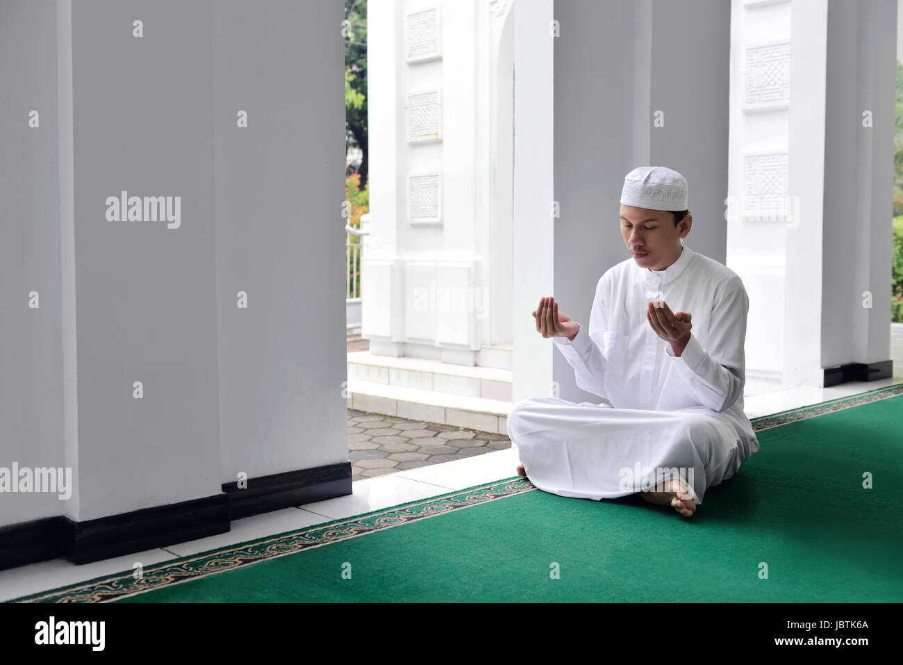 Handsome asian muslim man raising hand and praying on the mosque Stock ...