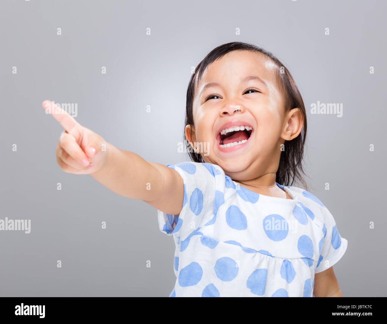 Happy girl point up Stock Photo - Alamy