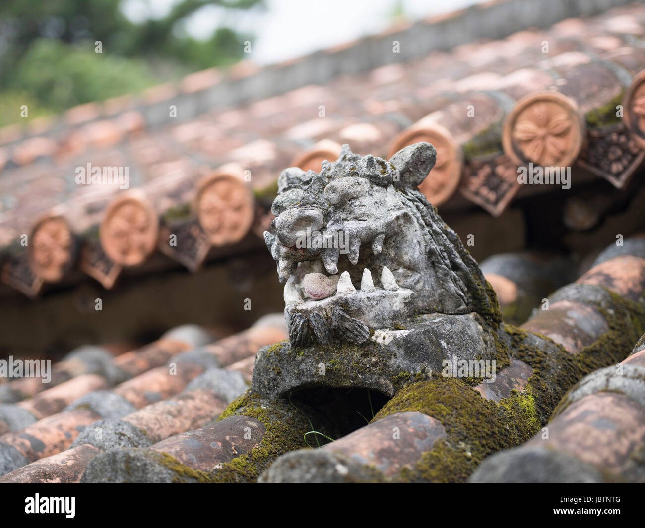 Plaster shisa on the roof of a red tile building at Ryukyu Mura ...