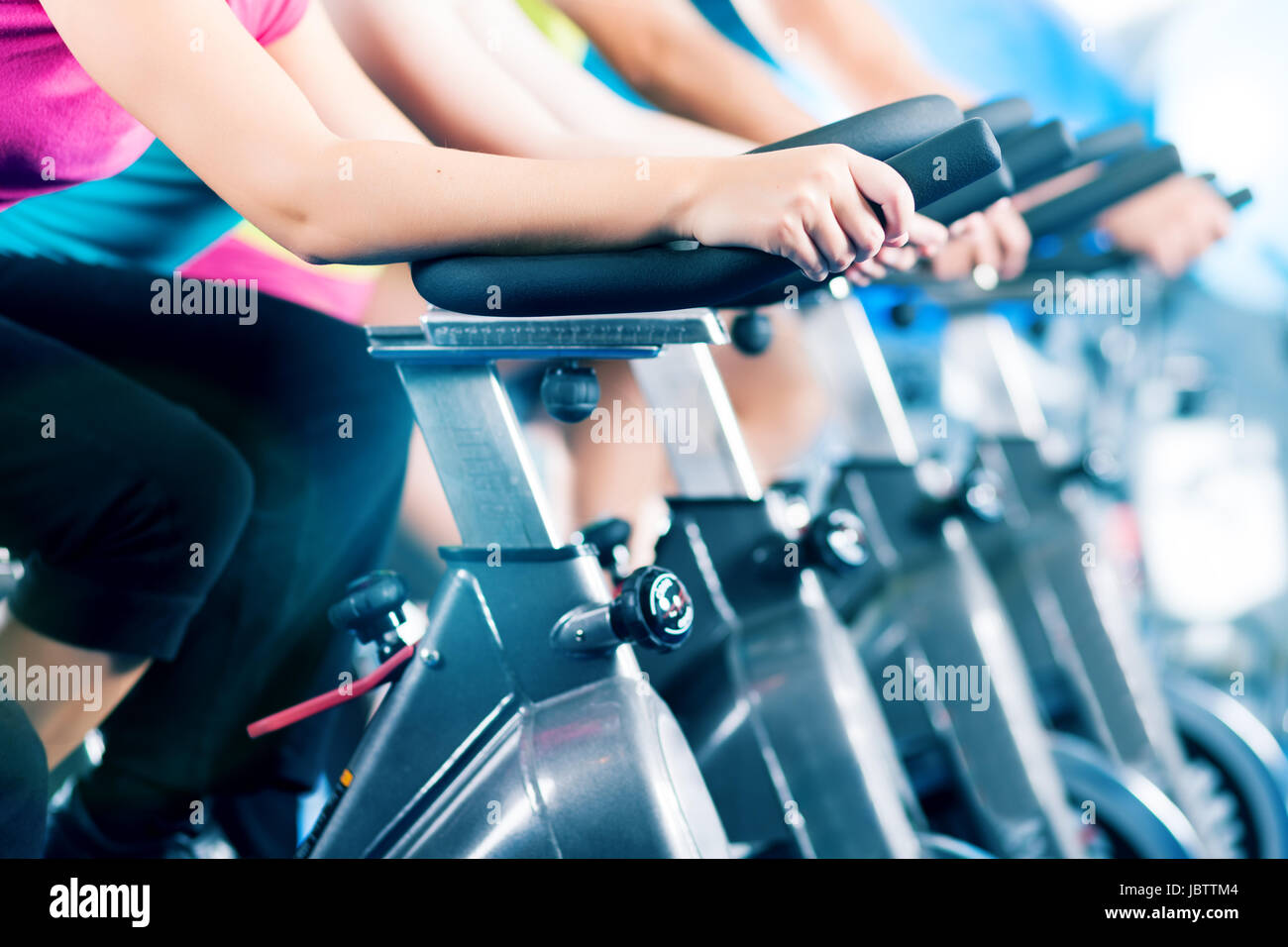 Group of four people spinning in the gym, exercising their legs doing ...
