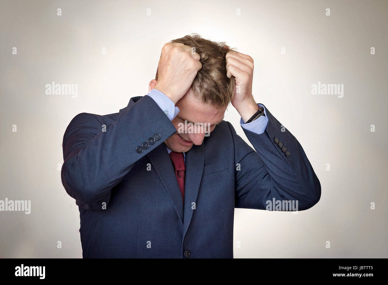 Young man in the suit pulling his hair Stock Photo - Alamy
