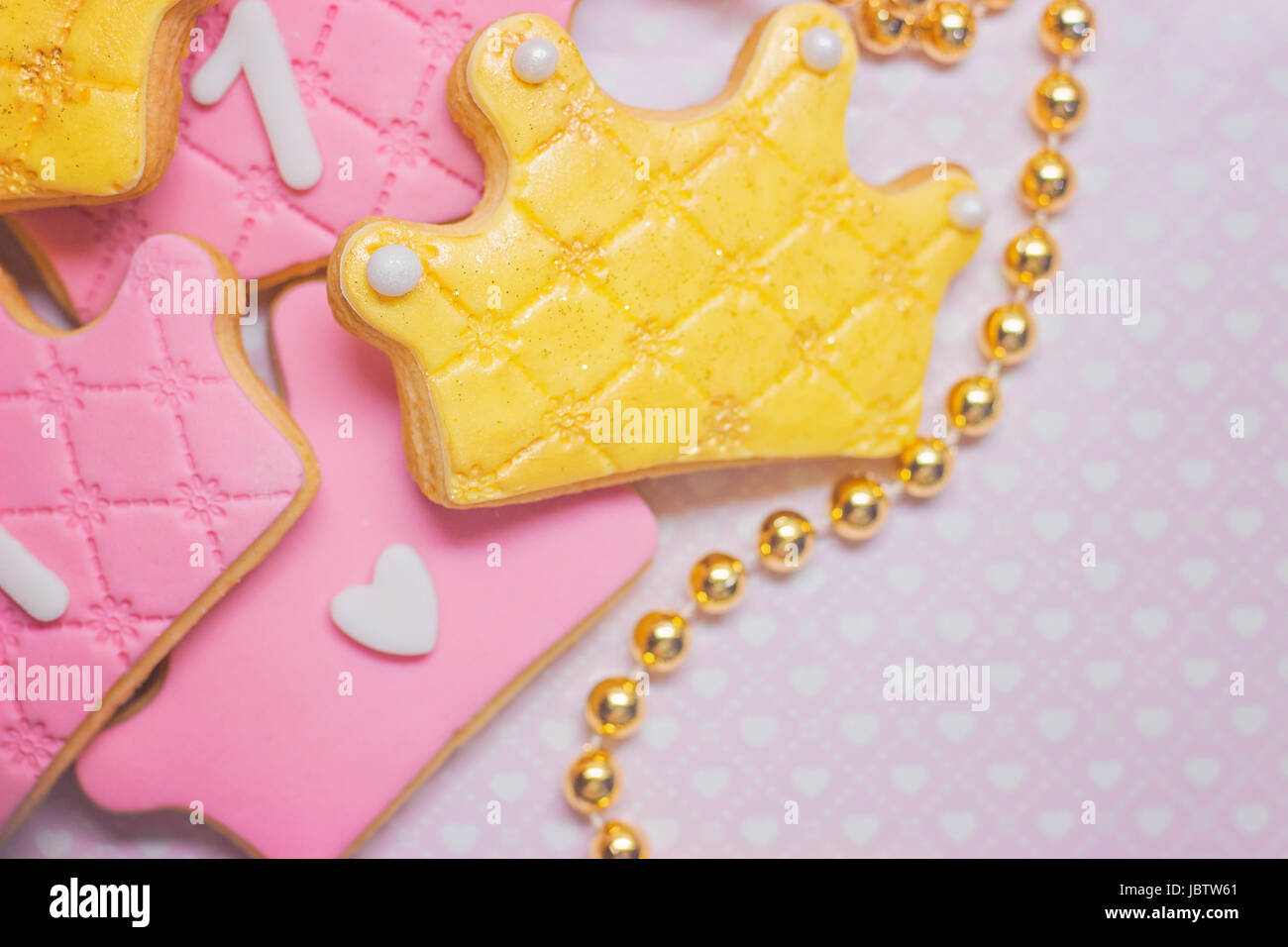 First birthday, crown shaped royal icing cookies on pink background ...