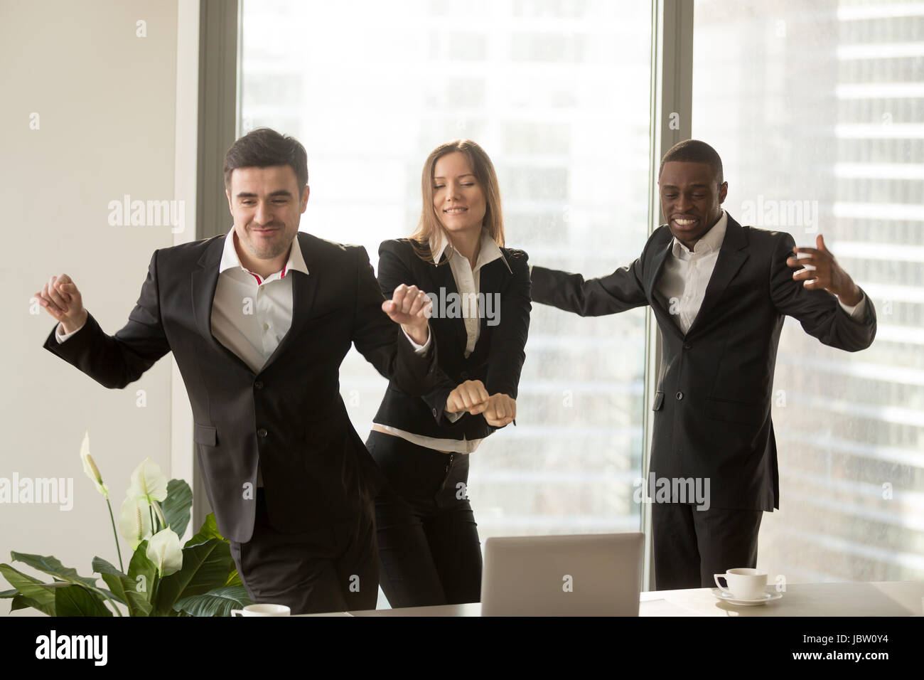 Excited african and caucasian employees dancing in office, staff party ...